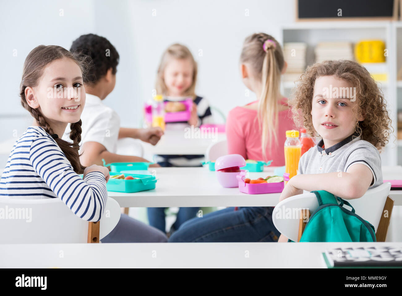 Smiling girl and boy eating healthy breakfast during break at school ...