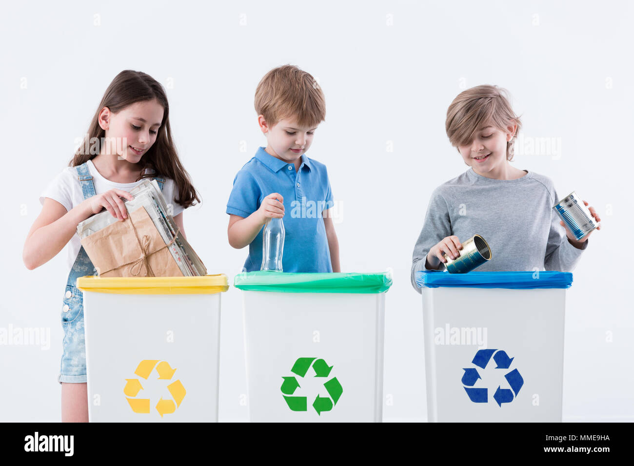 Children segregating paper, glass and metal into yellow, green and blue ...
