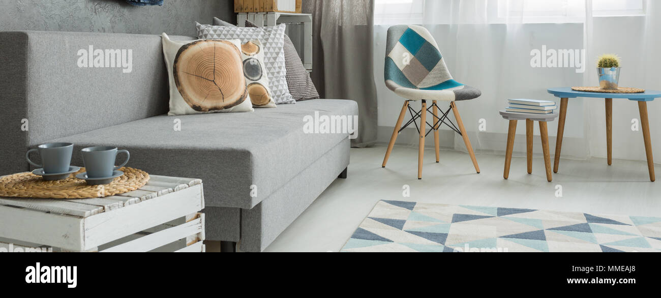 Panoramic photo of a harmonious living room arranged in bright colours ...