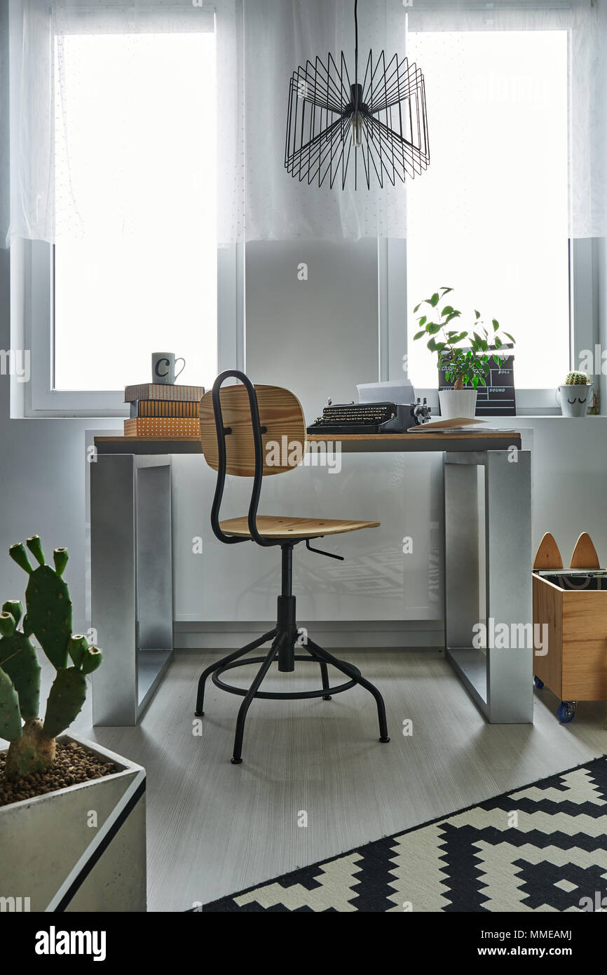 Room with simple desk, wooden chair and window Stock Photo - Alamy