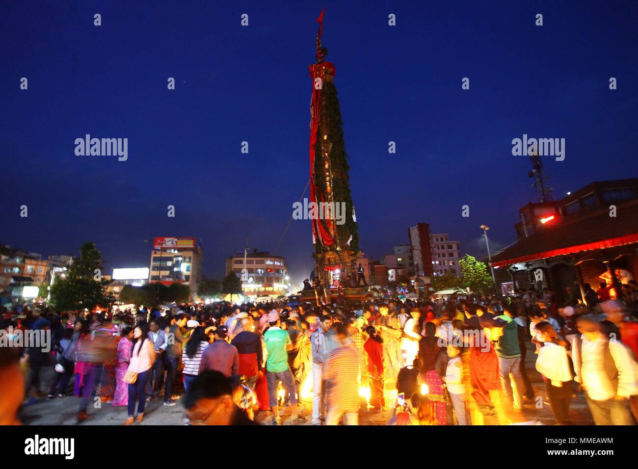 People participate in the chariot procession in celebration of a month ...