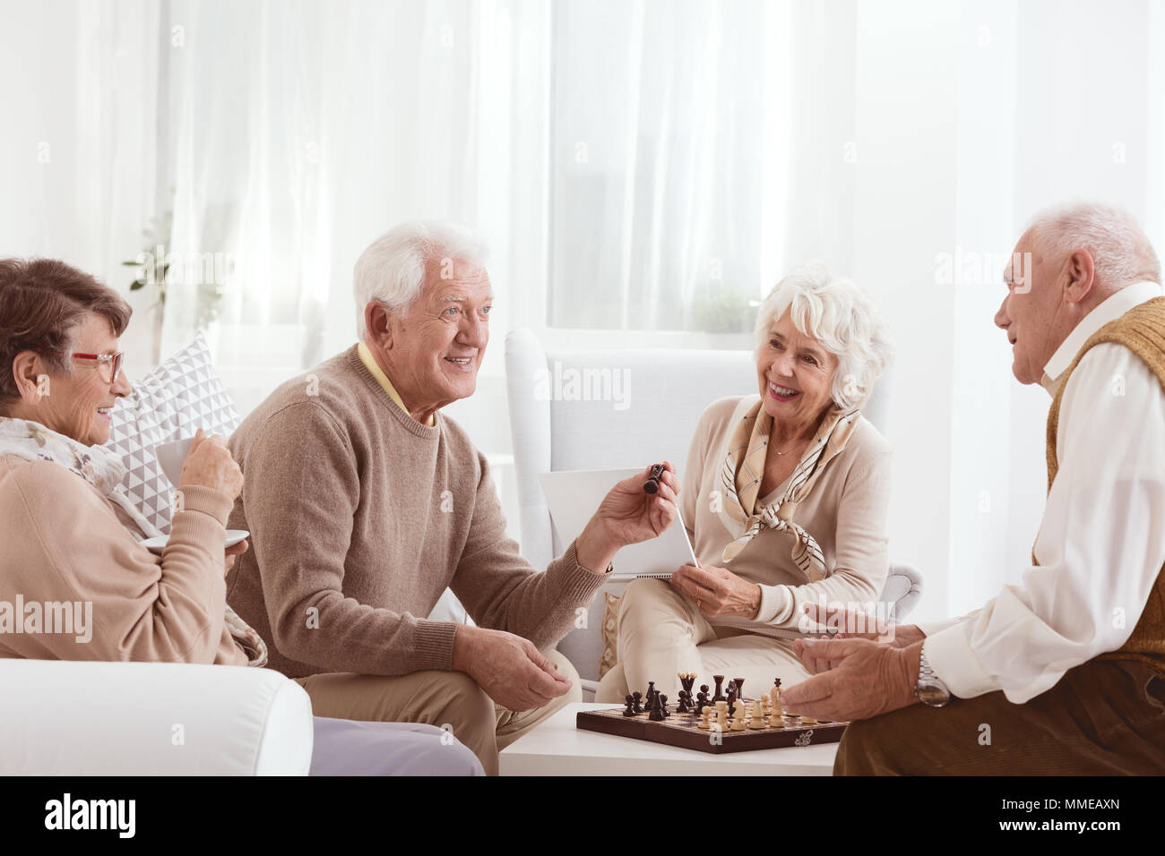 Group of happy seniors playing chess together Stock Photo - Alamy