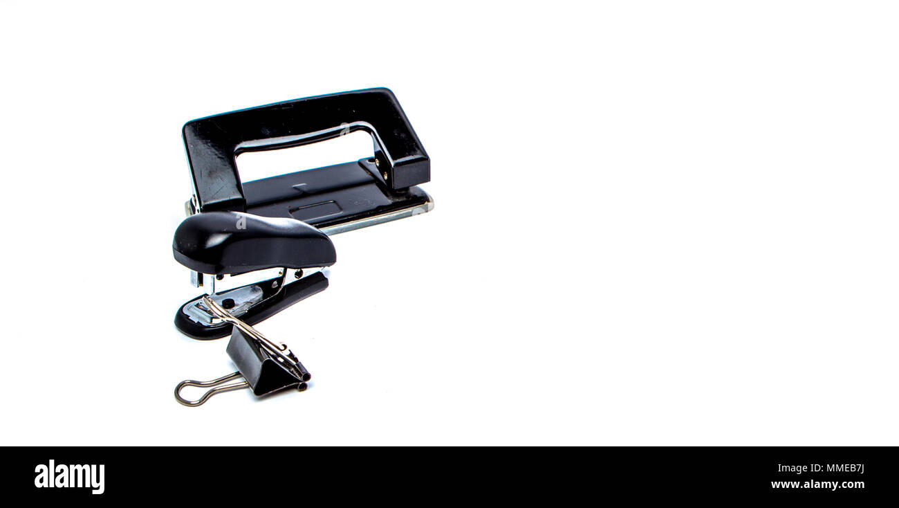 hole puncher, staple puller or staple remover and paper clips isolated ...