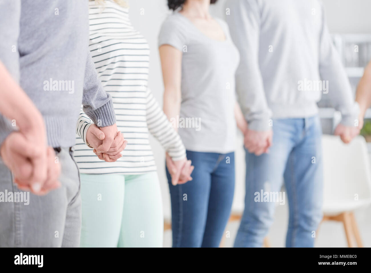 People holding hands during support group meeting Stock Photo - Alamy