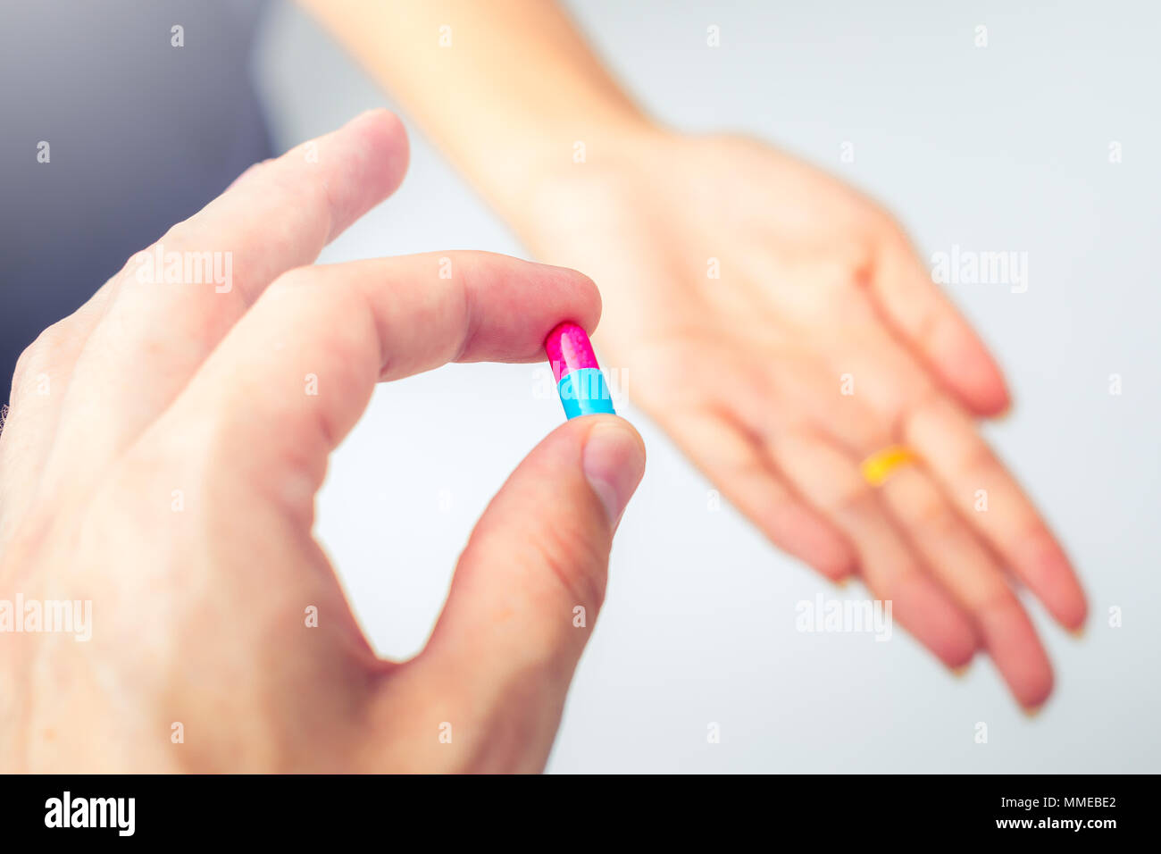 Hand of a doctor giving a drug pill to his patient Stock Photo - Alamy