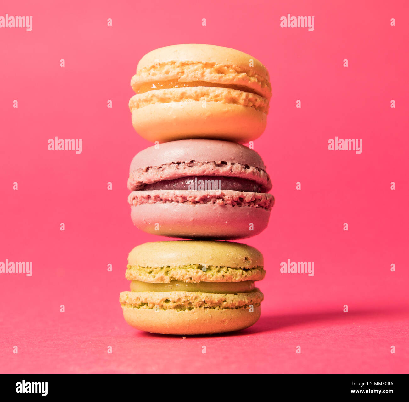 Stack of three macarons on a pink background Stock Photo - Alamy