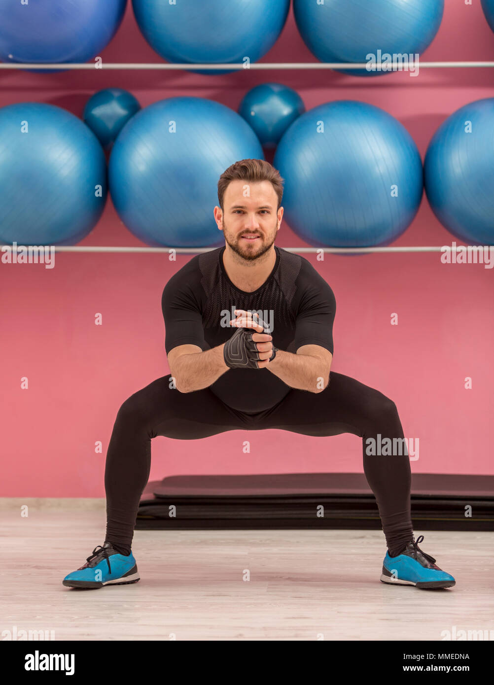 Young man doing stretching exercises in a gym Stock Photo - Alamy