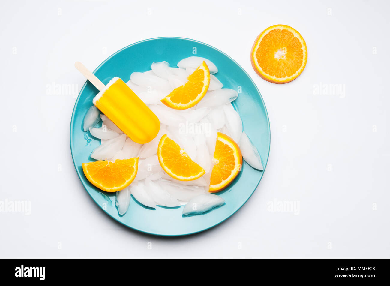 Orange Popsicle on a plate of ice cubes Stock Photo - Alamy