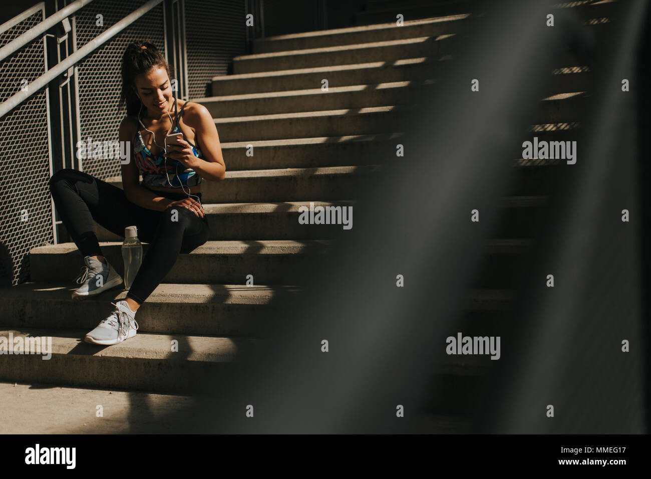 Portrait of pretty young female runner resting on stairs Stock Photo ...