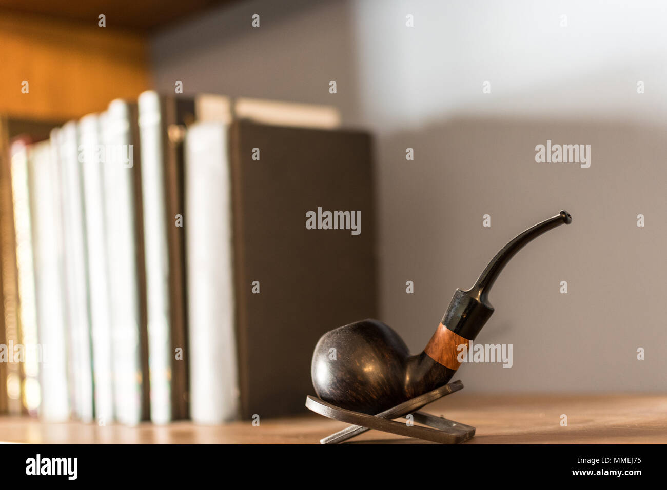Smoking pipe on a bookshelf Stock Photo - Alamy