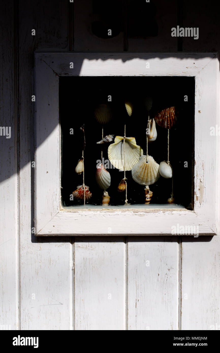 A shady white door window decorated in sea shells Stock Photo - Alamy