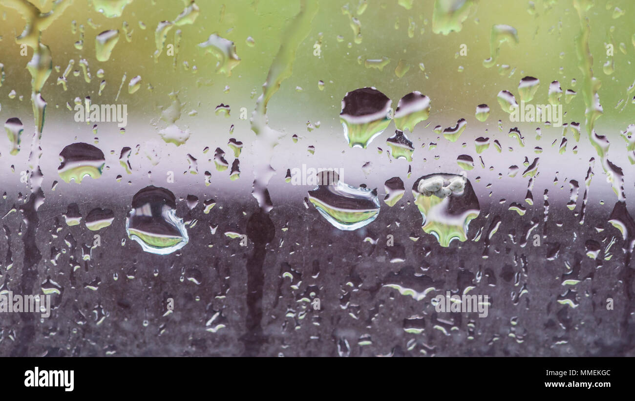 A macro shot of some raindrops dripping down a window Stock Photo - Alamy