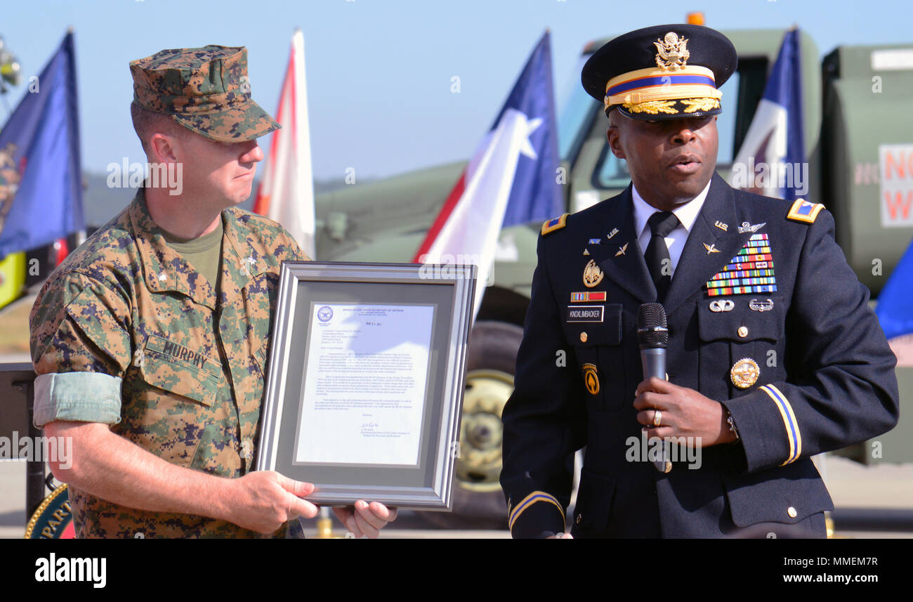 Col. Kodjo Knoxlimbacker (right) hands Lt. Col. Daniel Murphy ...