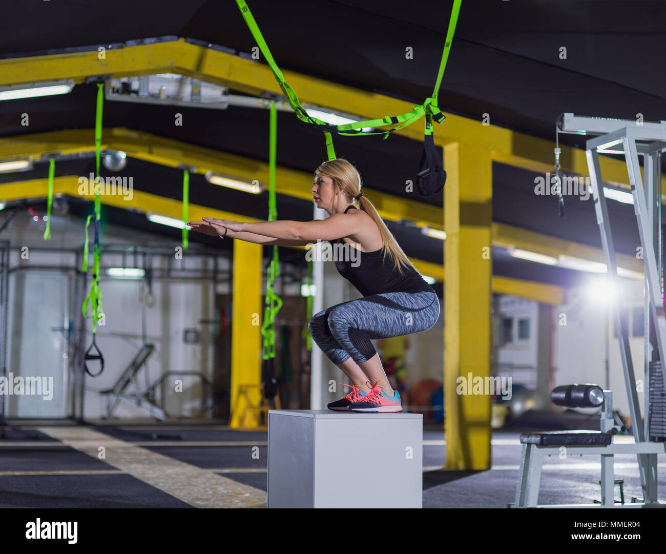 young athletic woman training jumping on fit box at crossfitness gym ...