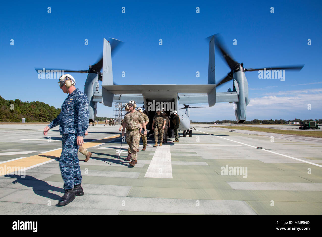 U.S. Marines, Sailors and distinguished guests depart a MV-22 Osprey ...