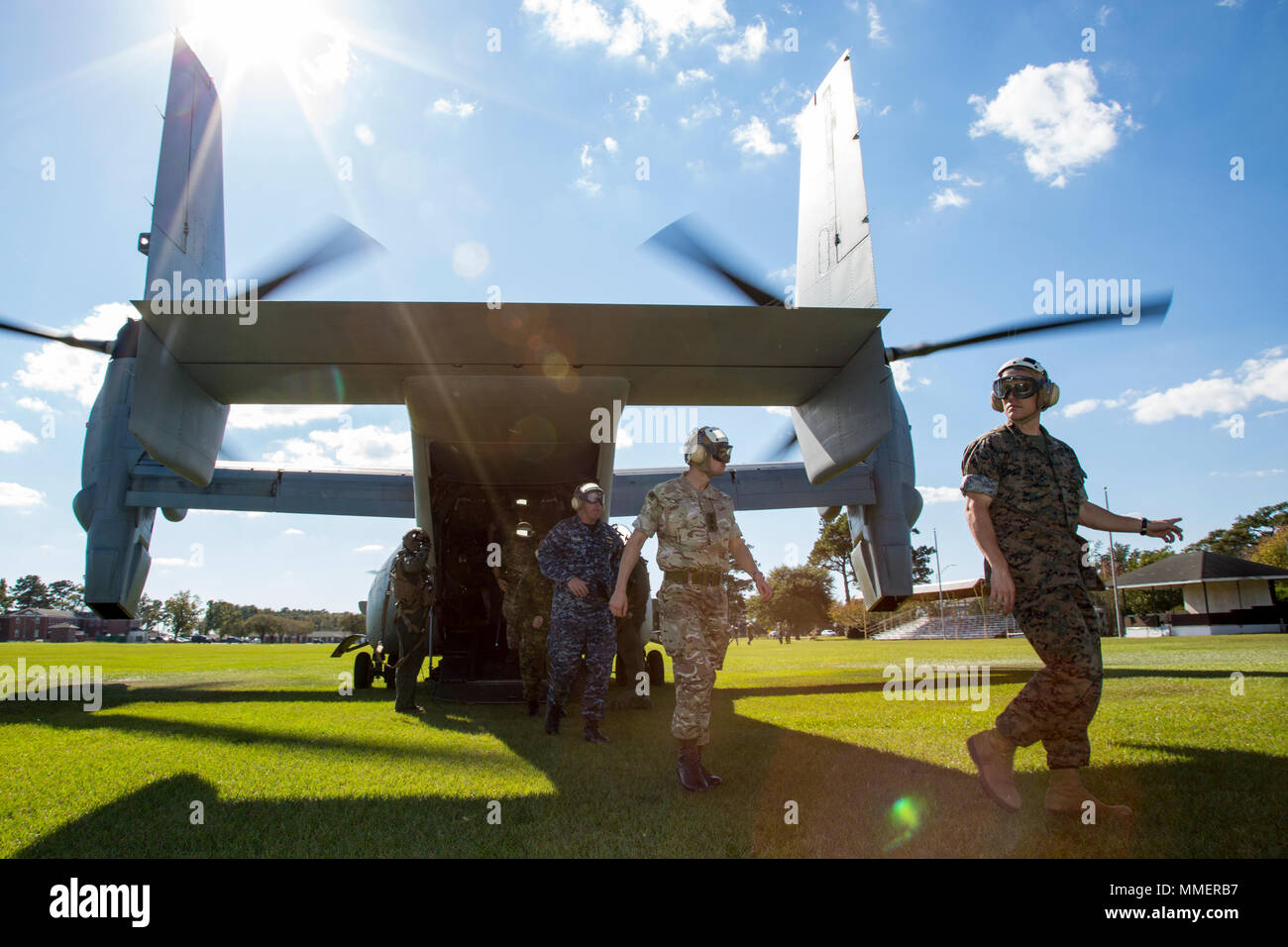 U.S. Marines, Sailors and distinguished guests depart a MV-22 Osprey ...