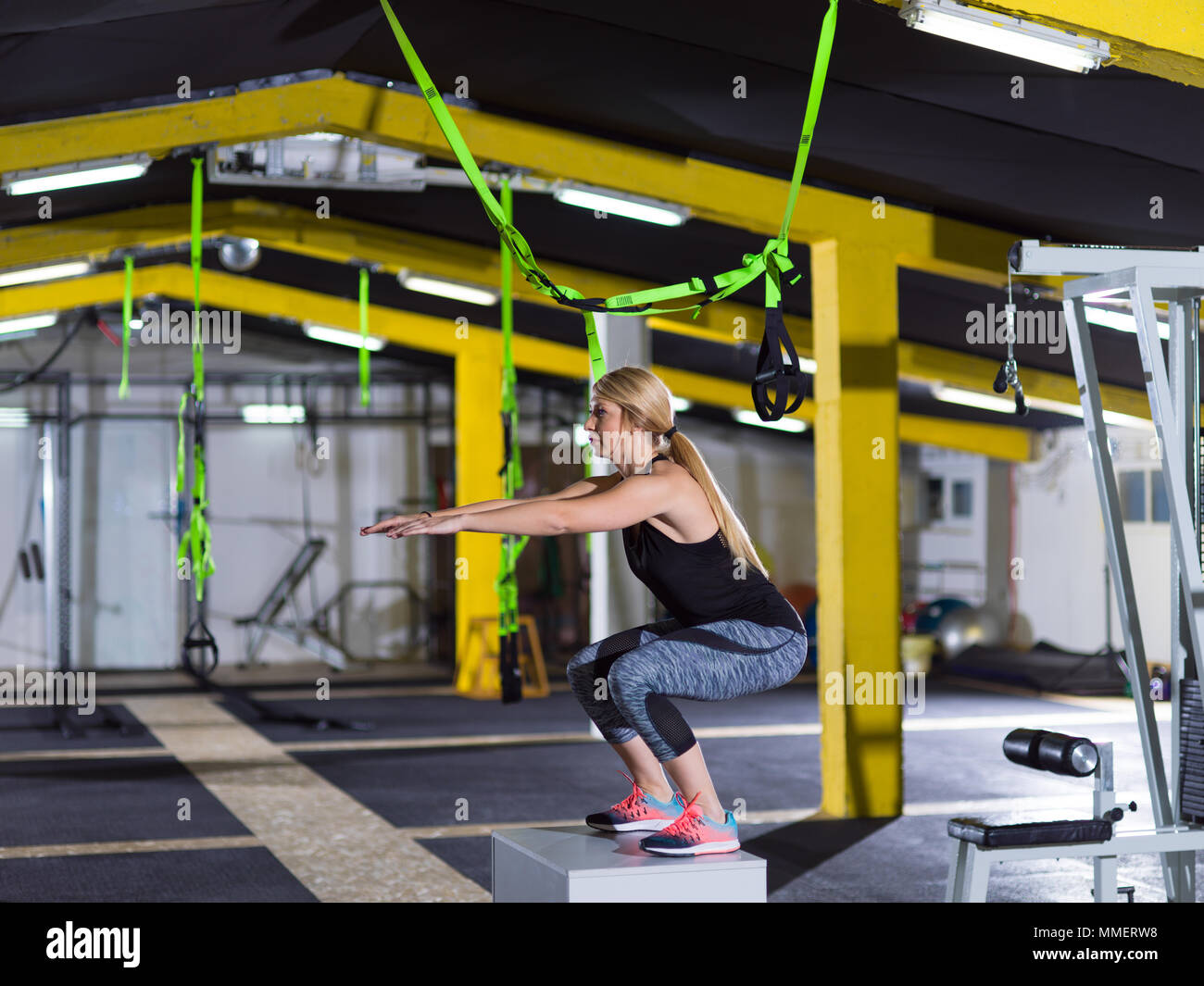 young athletic woman training jumping on fit box at crossfitness gym ...