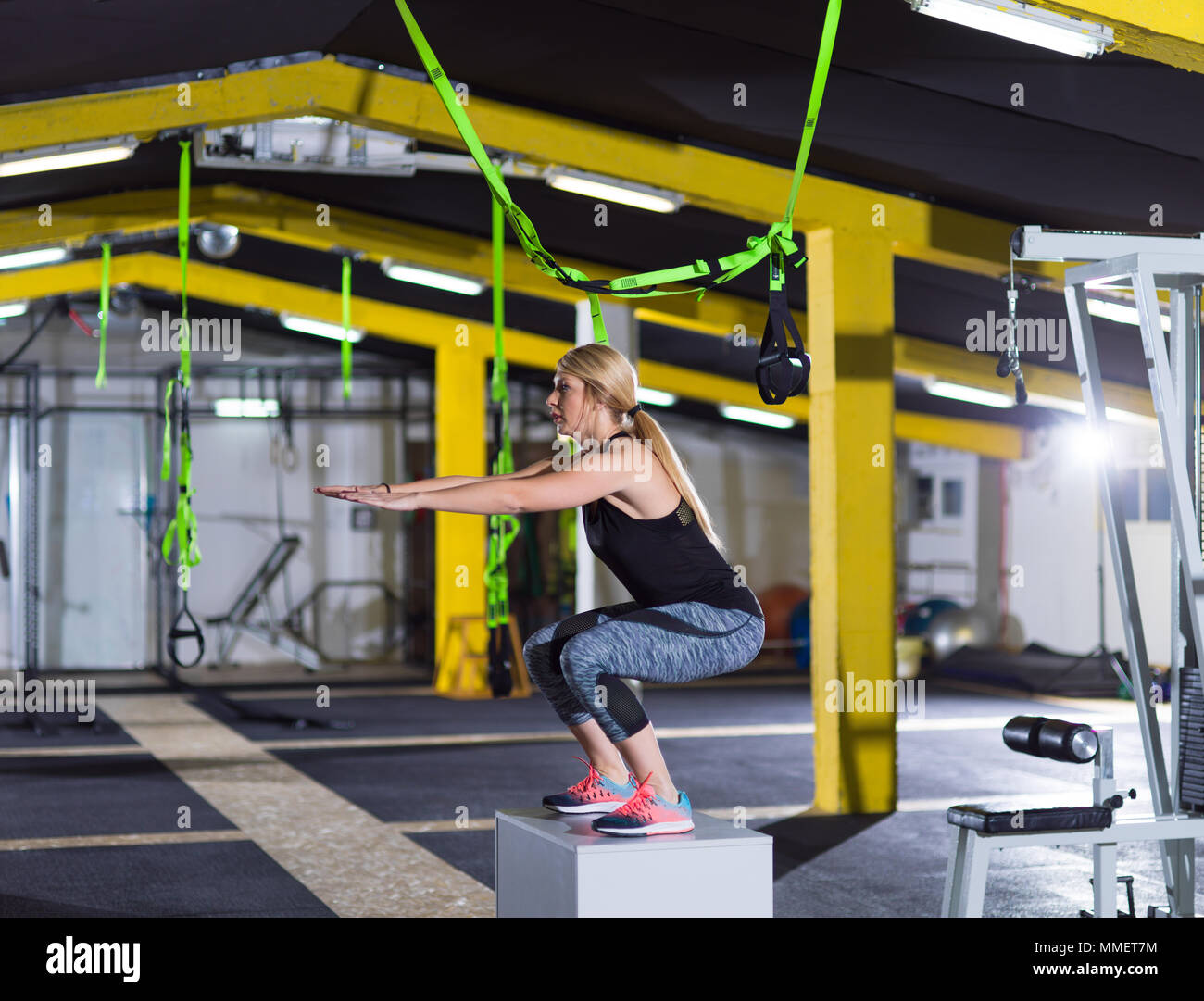 young athletic woman training jumping on fit box at crossfitness gym ...