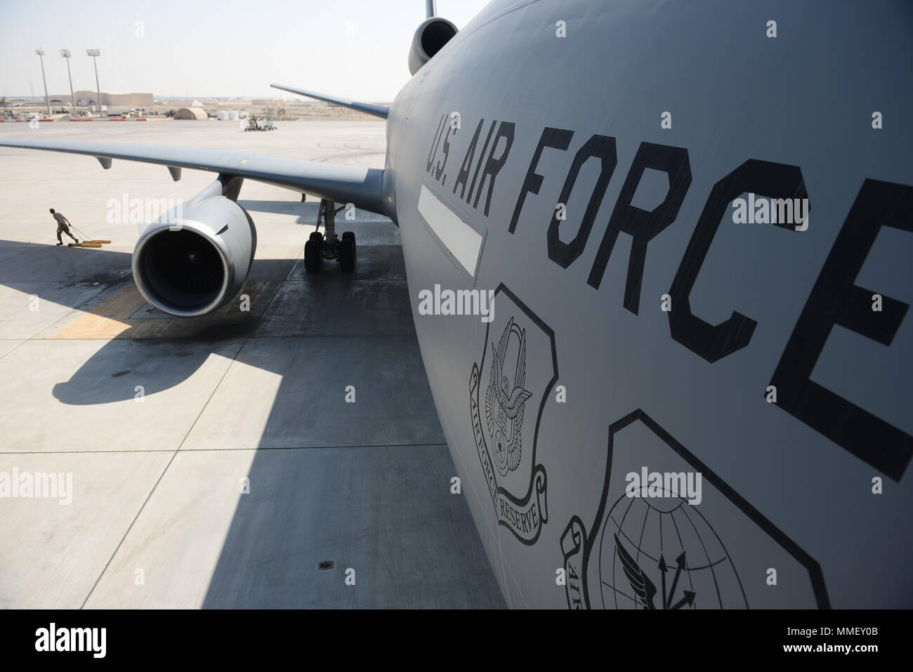 An aircraft maintainer pulls chalks out from under a KC-10 Extender ...