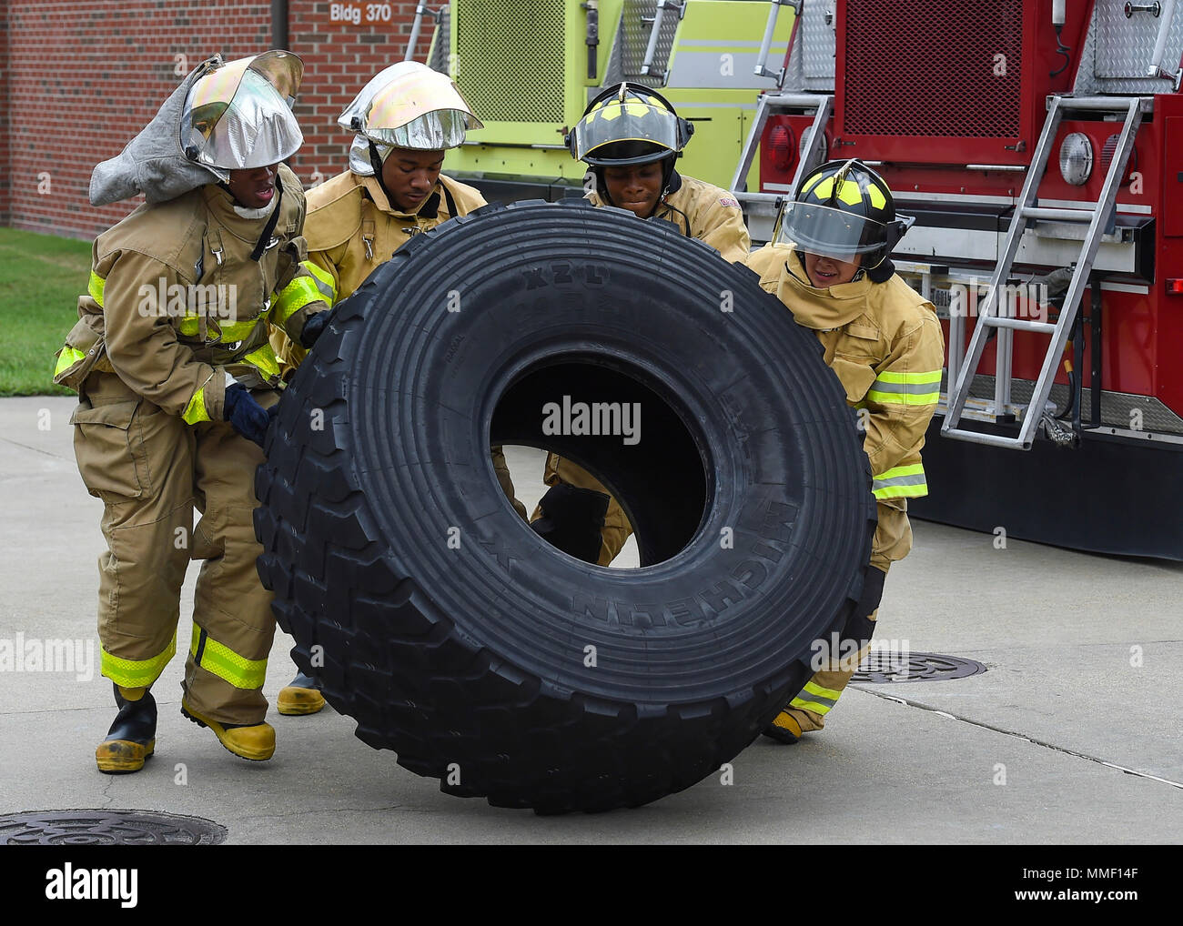 U.S. Air Force Airmen flip a tire during the Fire Prevention Week ...
