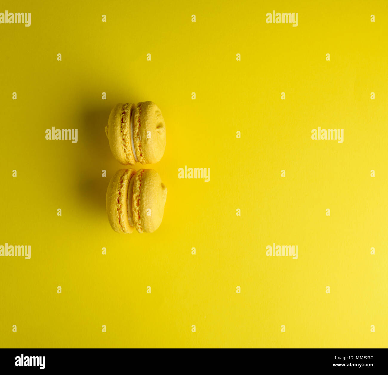 two yellow macarons on a yellow background, top view, copy space Stock ...