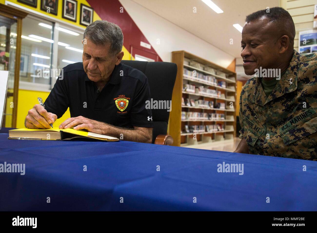 Retired U.S. Marine Corps Willis "Bill" Hansen signs a library book ...