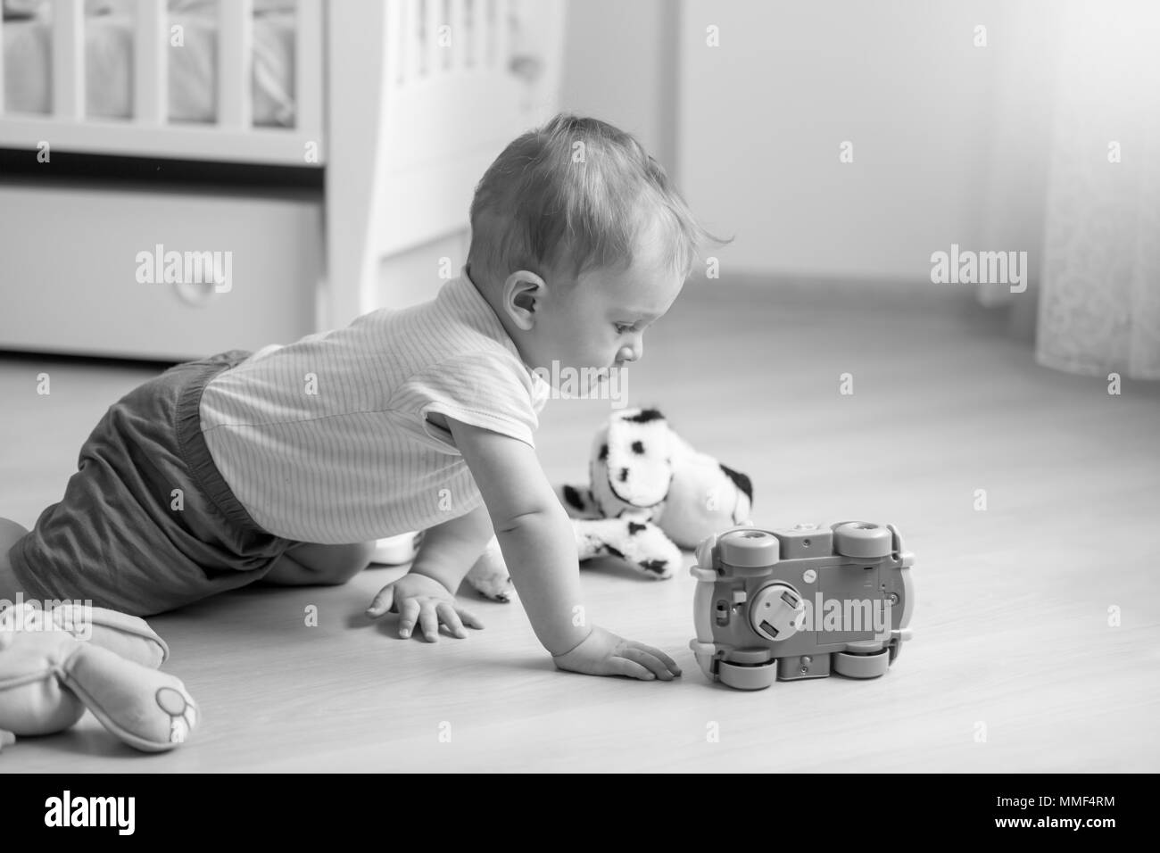 Black and white photo of adorable toddler boy crawling on floor towards ...