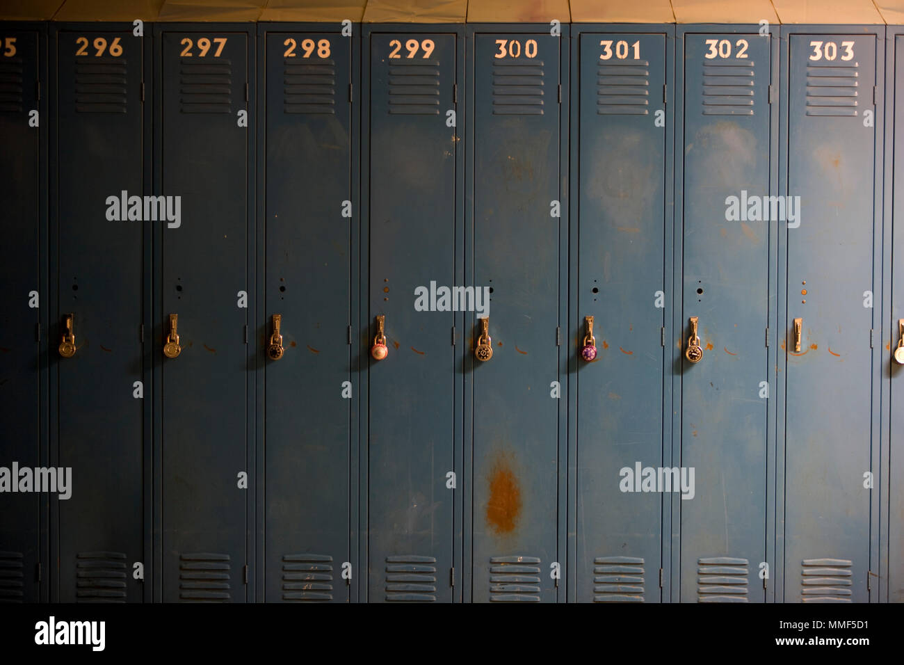 Still life of used beat up steel lockers with locks in a high school ...