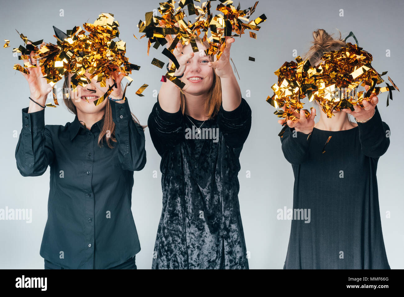 women throwing golden confetti Stock Photo - Alamy