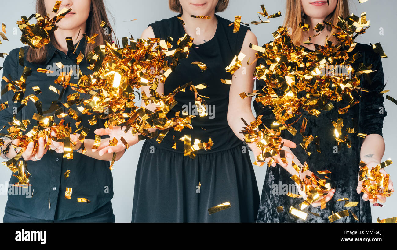 women throwing golden confetti Stock Photo - Alamy