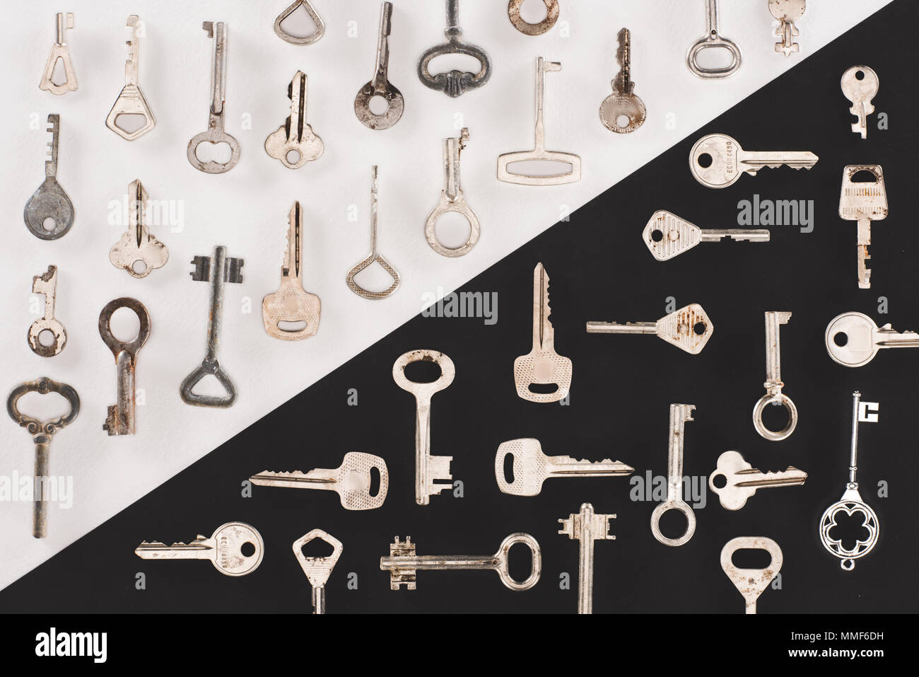 top view of different vintage keys over black and white background ...