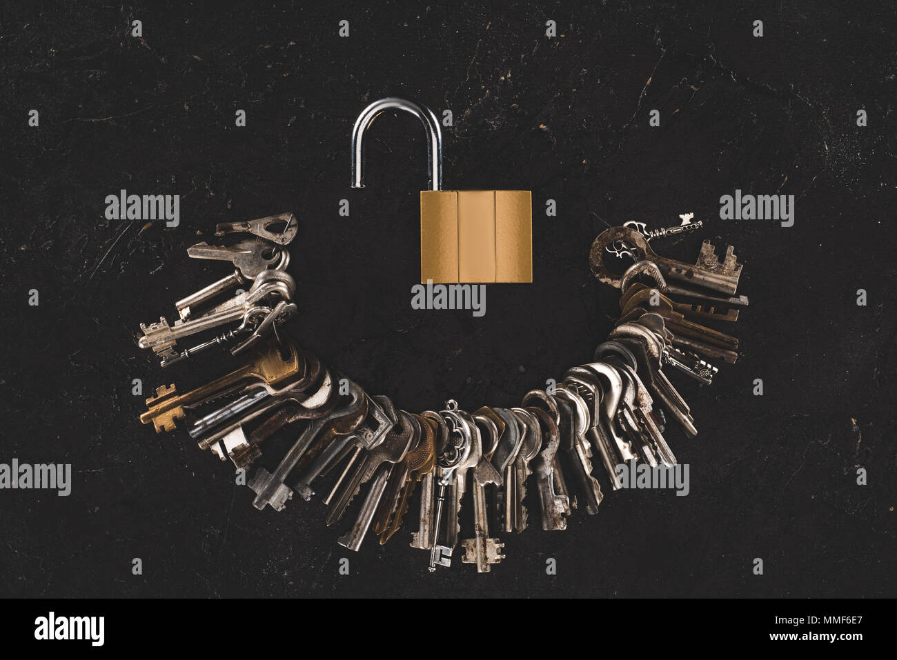top view of heap different metal keys with opened lock isolated on ...