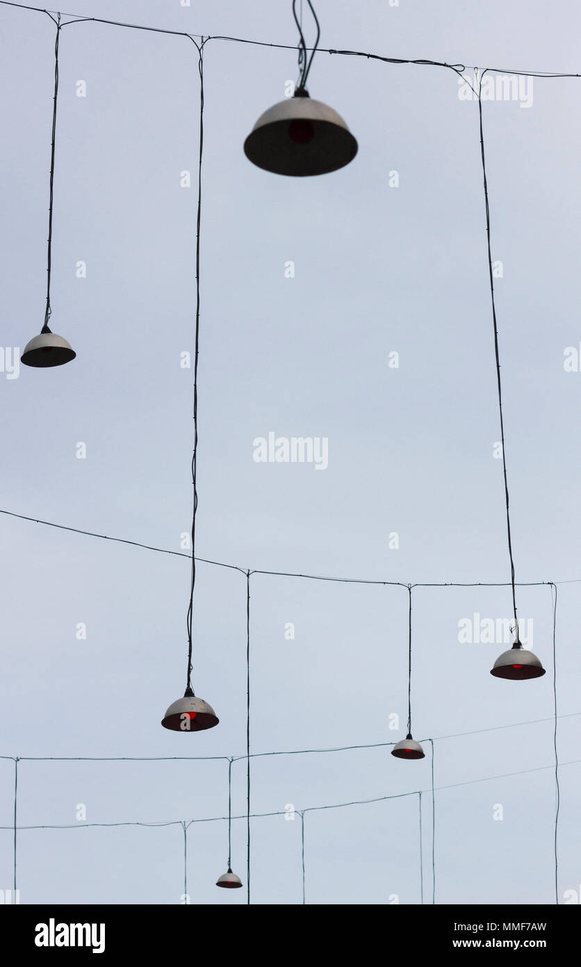 Five lamps with red bulbs hanging from wires in an alley in Berlin ...