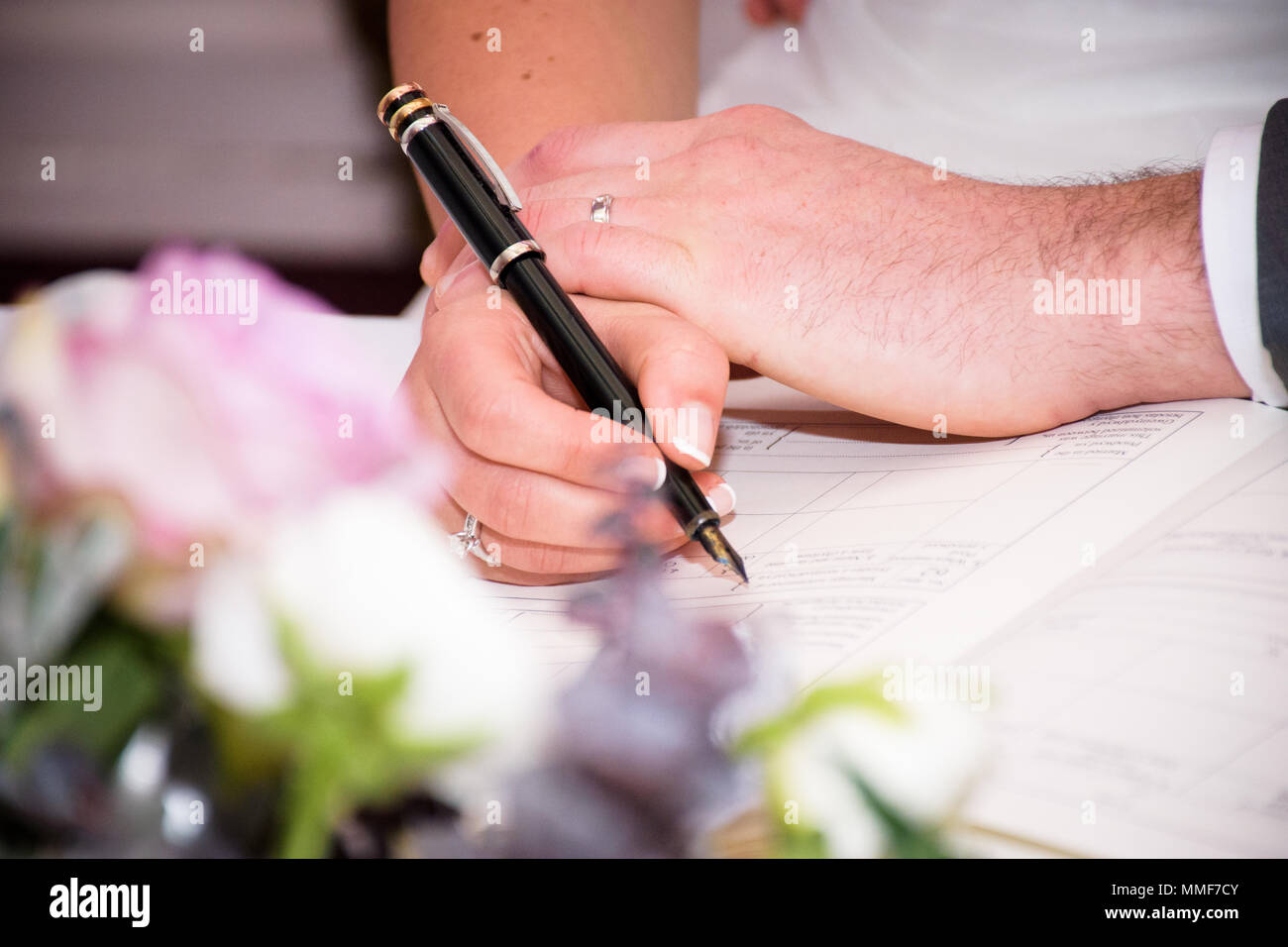 Bride & Groom signing wedding register documents. Focus on hand Stock ...
