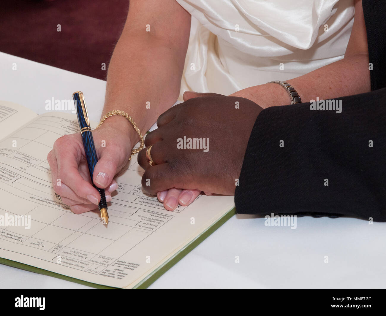Bride & Groom signing wedding register documents. Focus on hand Stock ...