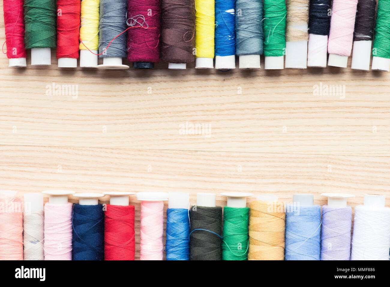 colorful frame of stitchings over wooden background with copy space ...