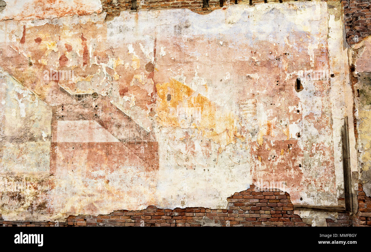 Photo of a colorful old decaying brick wall with peeling paint and ...