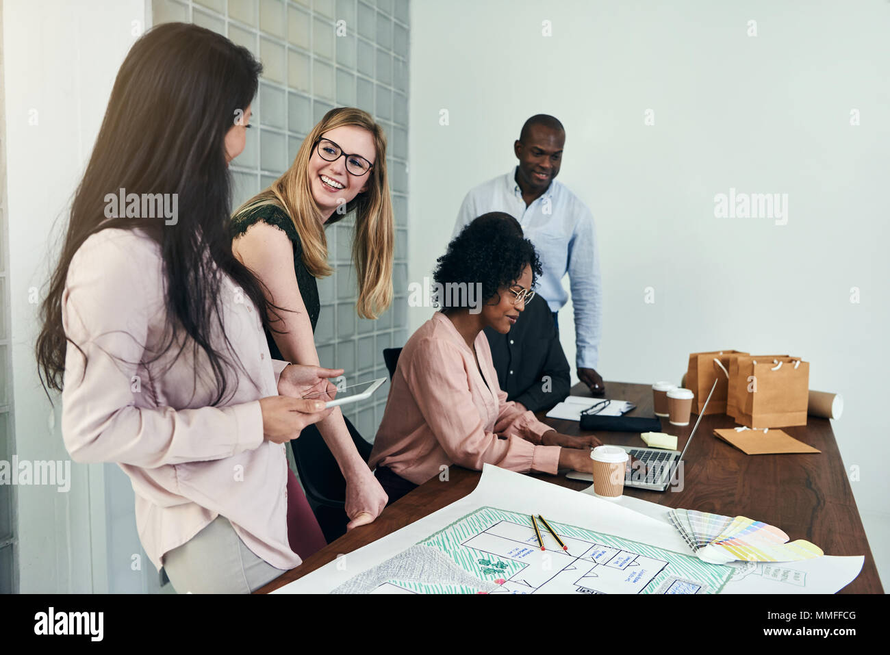 Diverse group of work colleagues smiling and having a discussion ...