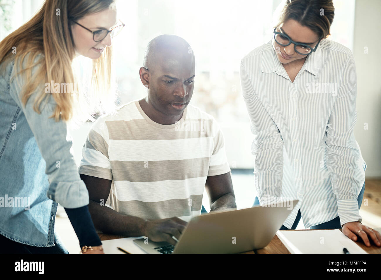 Three diverse design colleagues working together online with a laptop ...