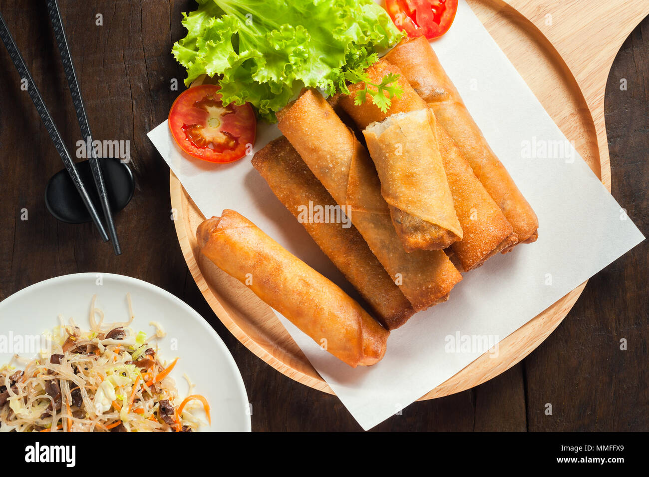 Crispy fried spring rolls with plum sauce and salad, lemon slices on ...