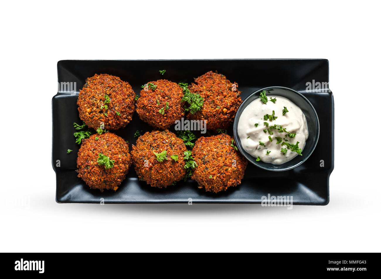 Fresh falafel with parsley and tzatziki sauce in black plate on white ...