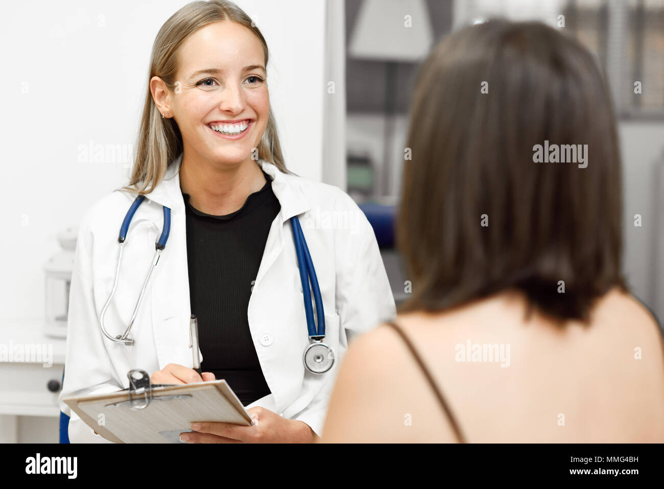 Female doctor explaining diagnosis to her patient. Brunette woman ...