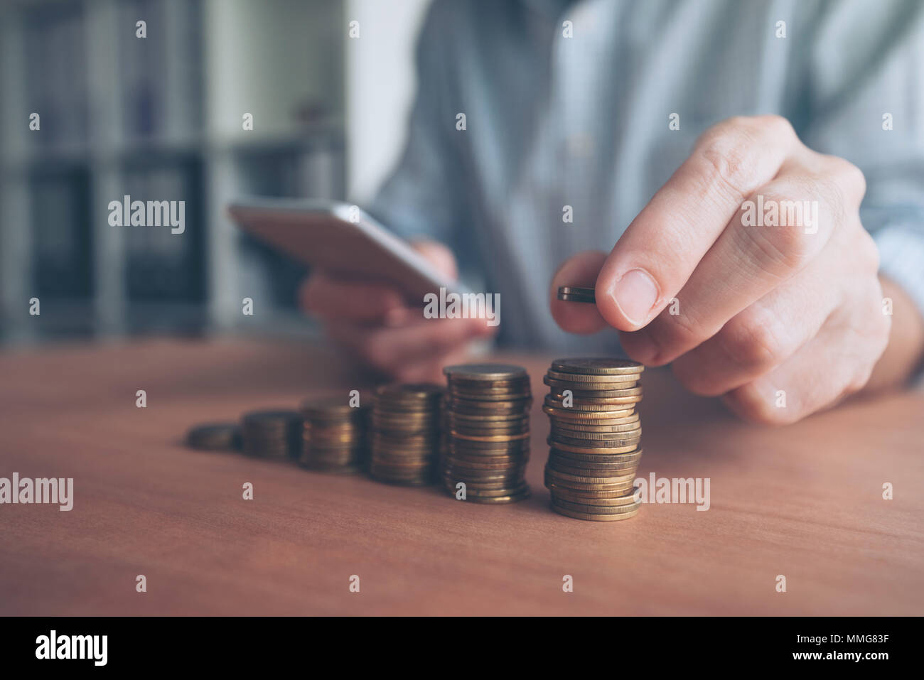Coin stacker, businessman with stacked money in the office doing ...