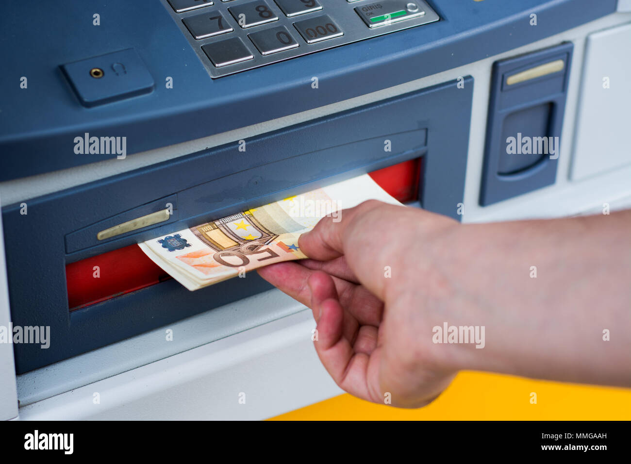 Taking money out of the ATM Stock Photo - Alamy