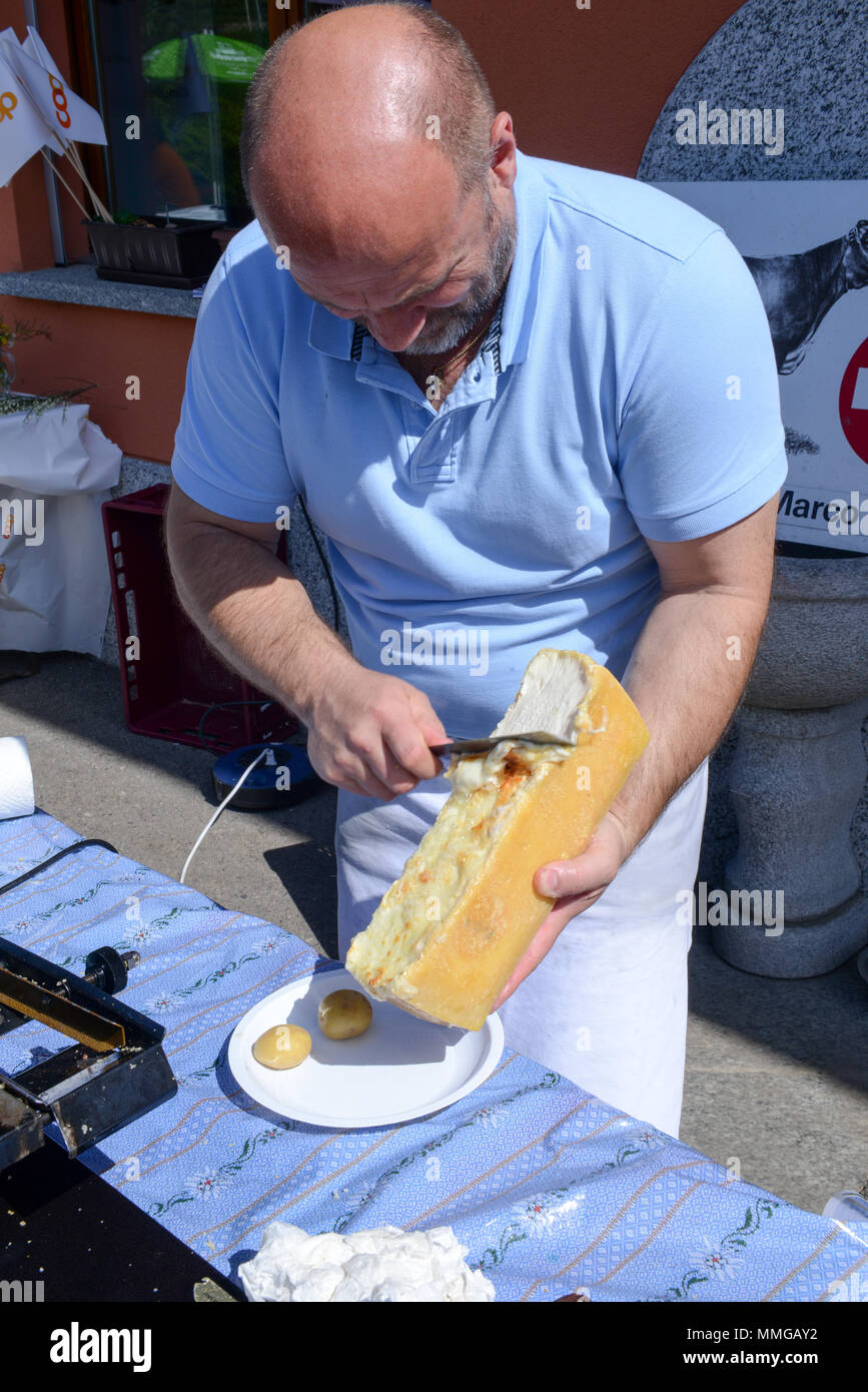Mugena, Switzerland - 7 May 2018: man preparing a portion of raclette ...
