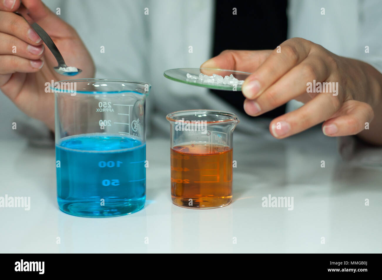 Flask in scientist hand and test tubes in rack Stock Photo - Alamy