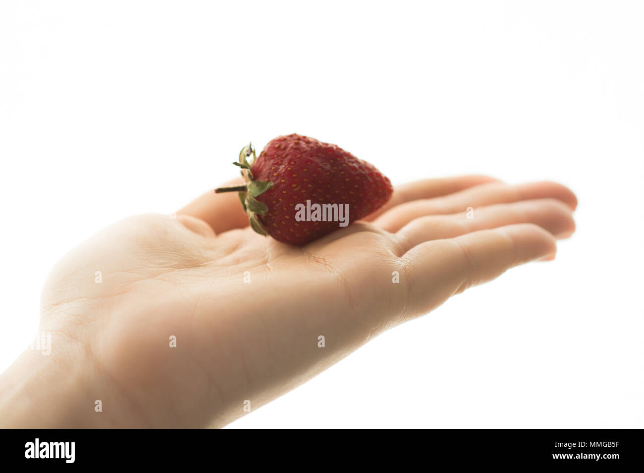 Hand and red strawberry Stock Photo - Alamy
