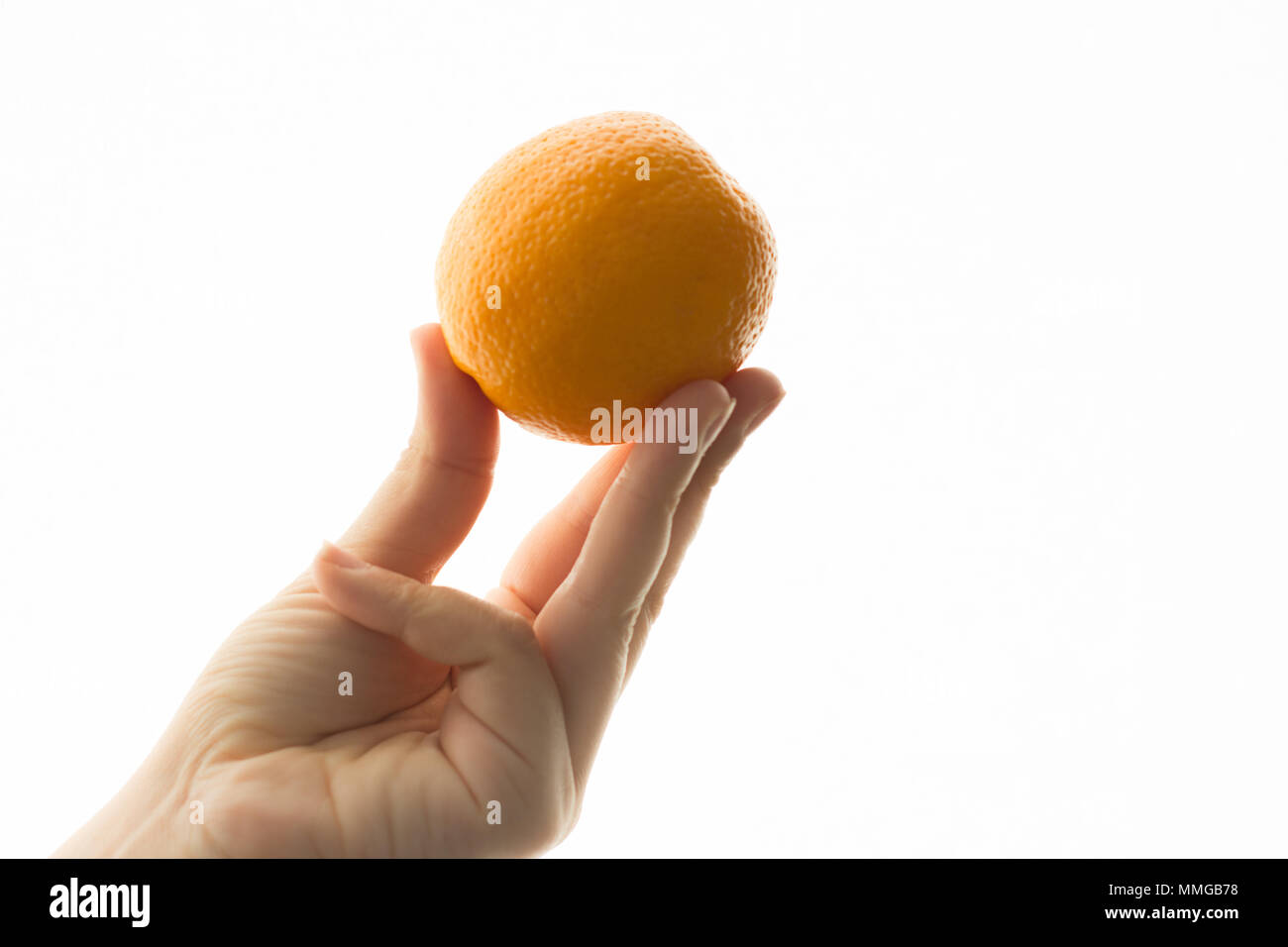 Hand holding an orange Stock Photo - Alamy