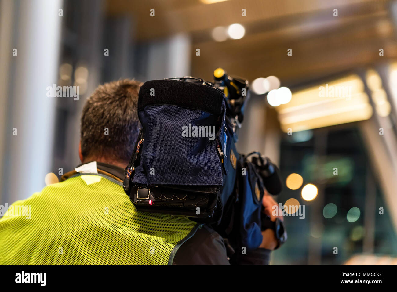 Back view cameraman filming news indoors Stock Photo - Alamy