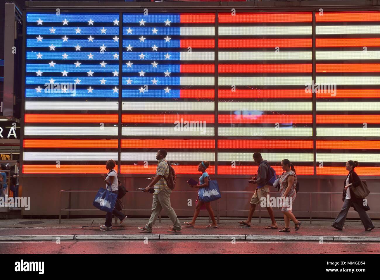 People walking past Neon sign of American Flag on Times Square,New York ...